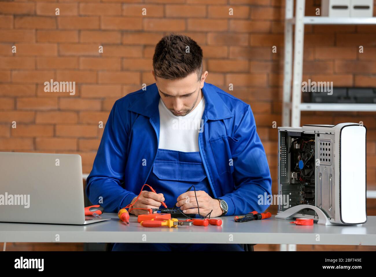 Electronic technician repairing computer in service center Stock Photo ...