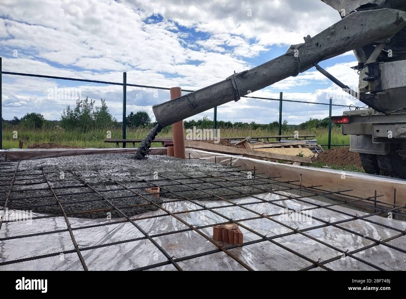 Pouring concrete after placing steel reinforcement to make a screed ...
