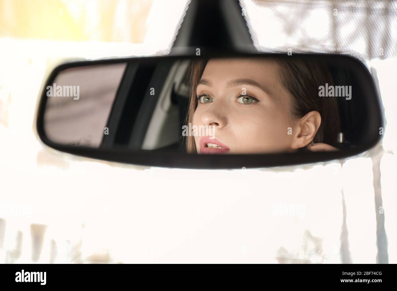 Reflection of driver in car rear view mirror Stock Photo - Alamy