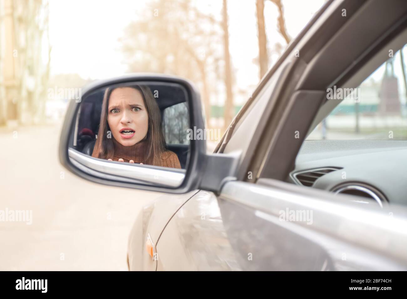 Reflection of worried driver in car side mirror Stock Photo - Alamy