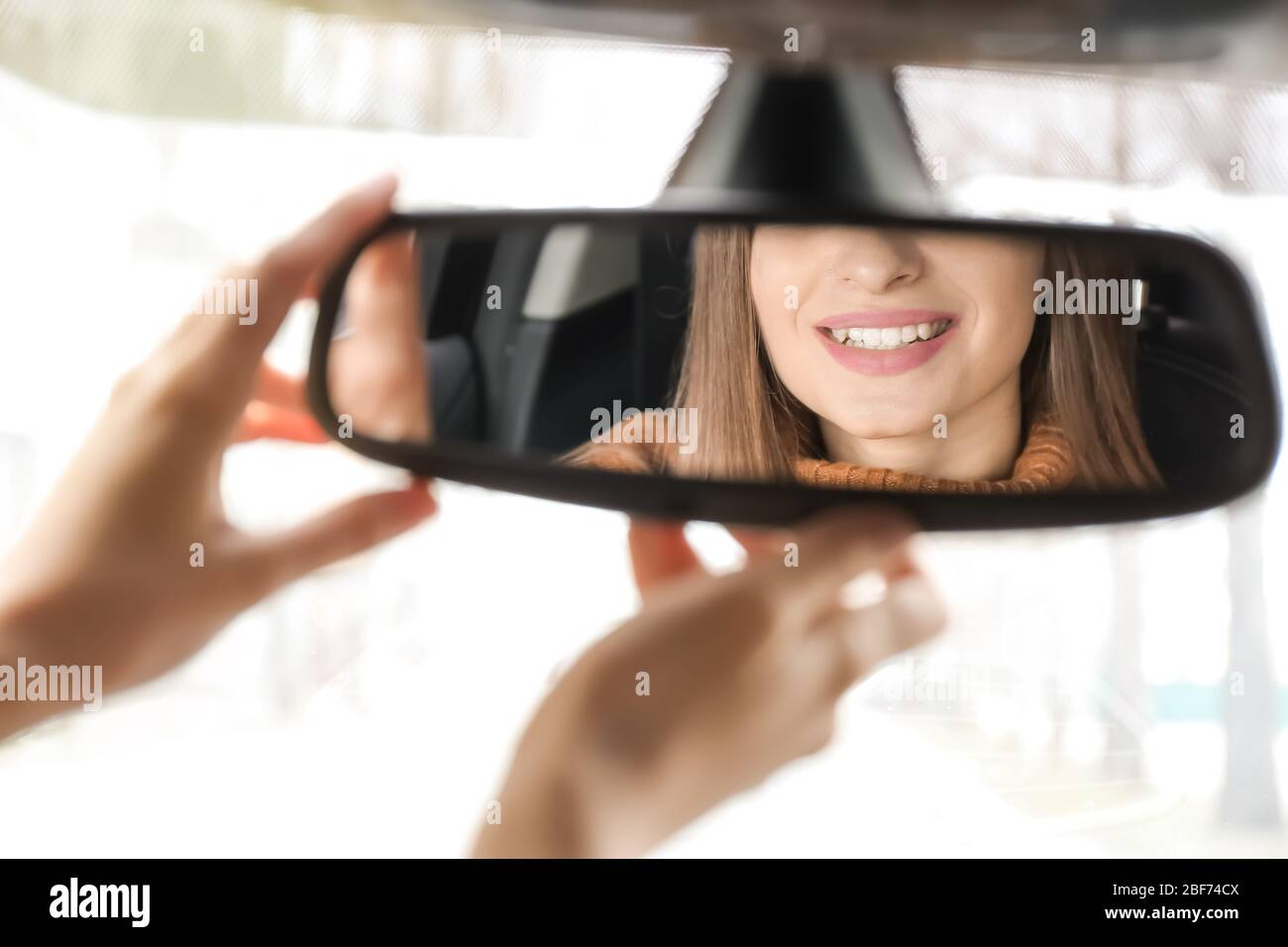 Driver adjusting rear view mirror in car Stock Photo - Alamy