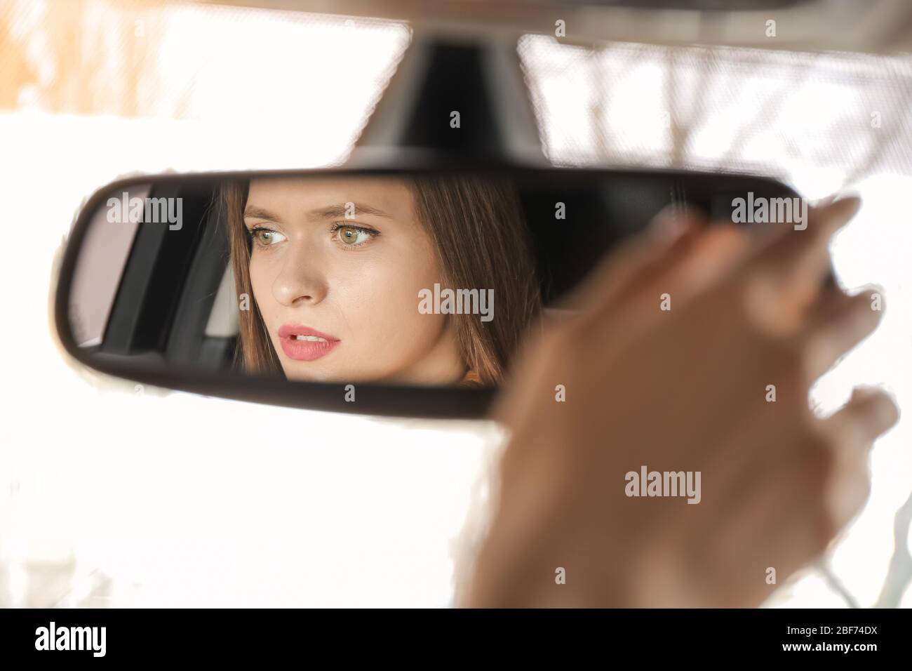 Driver adjusting rear view mirror in car Stock Photo - Alamy