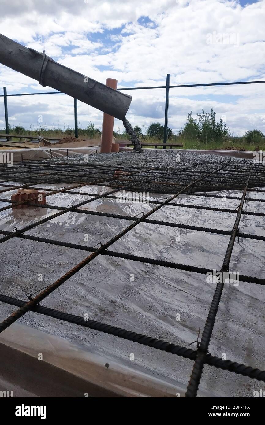 The concrete mixer feeds cement through the gutter to pour the concrete ...