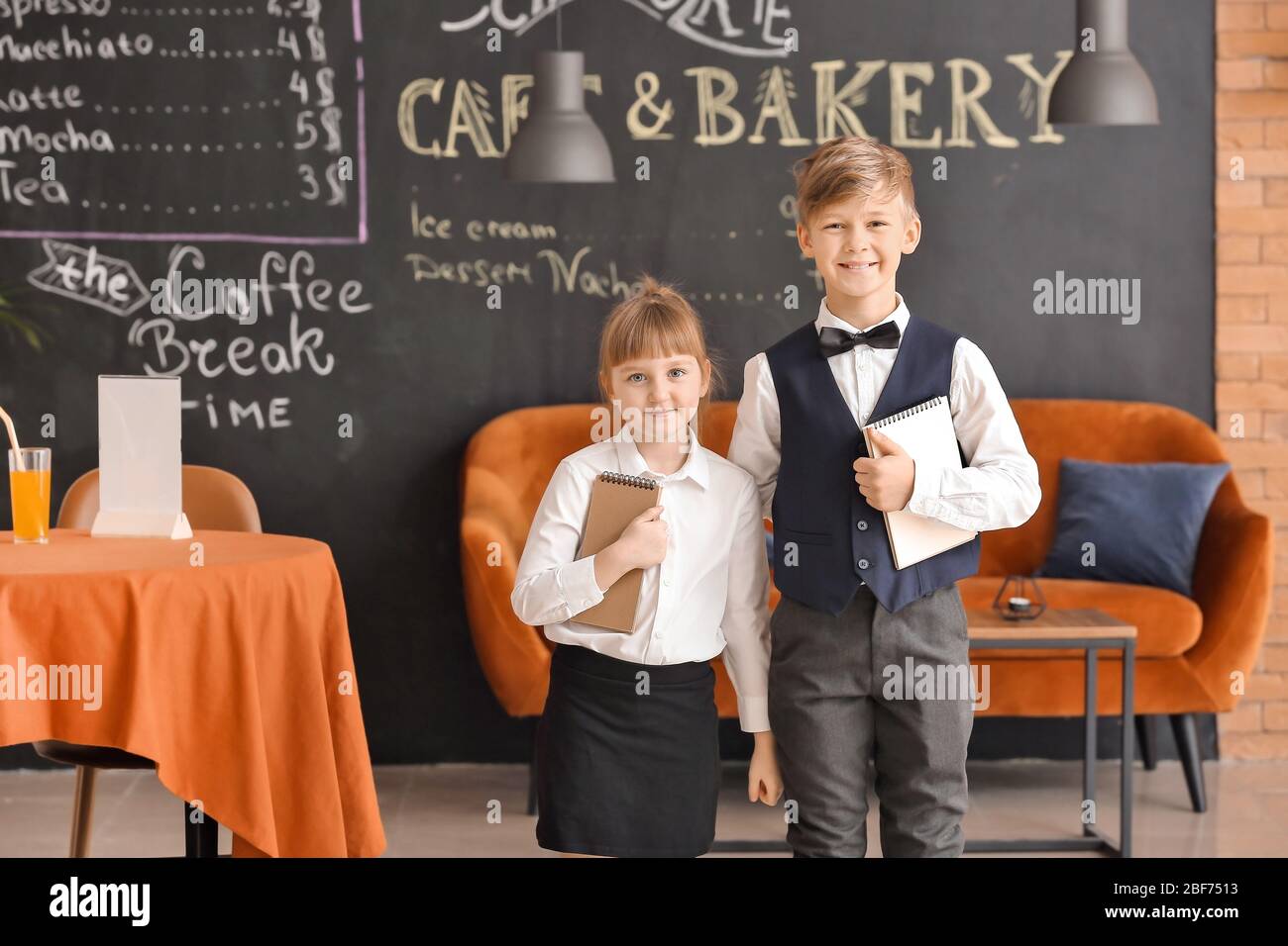 Cute little waiters in restaurant Stock Photo - Alamy
