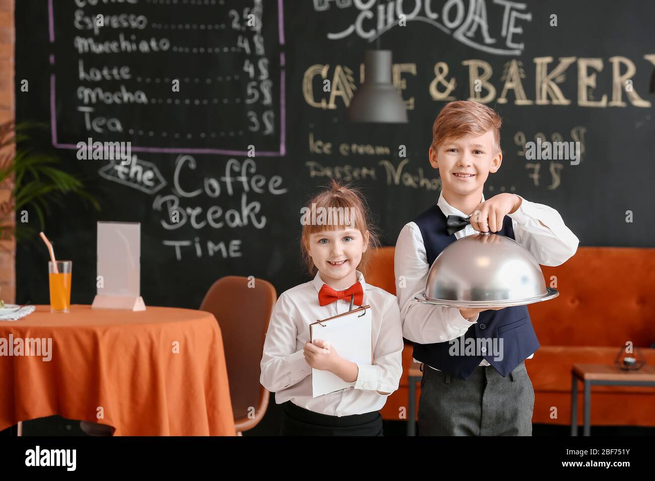 Cute little waiters in restaurant Stock Photo - Alamy