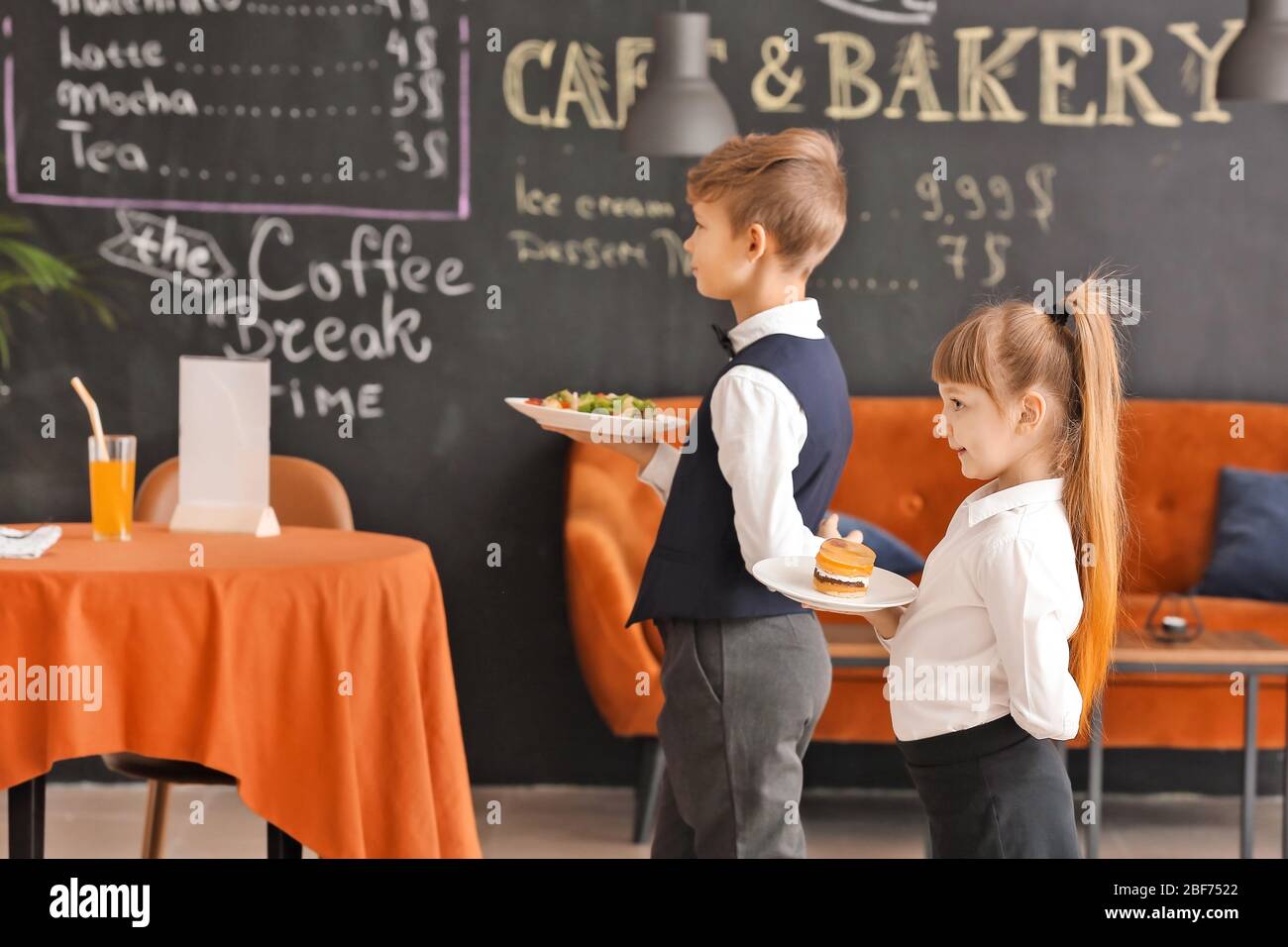 Cute little waiters in restaurant Stock Photo - Alamy