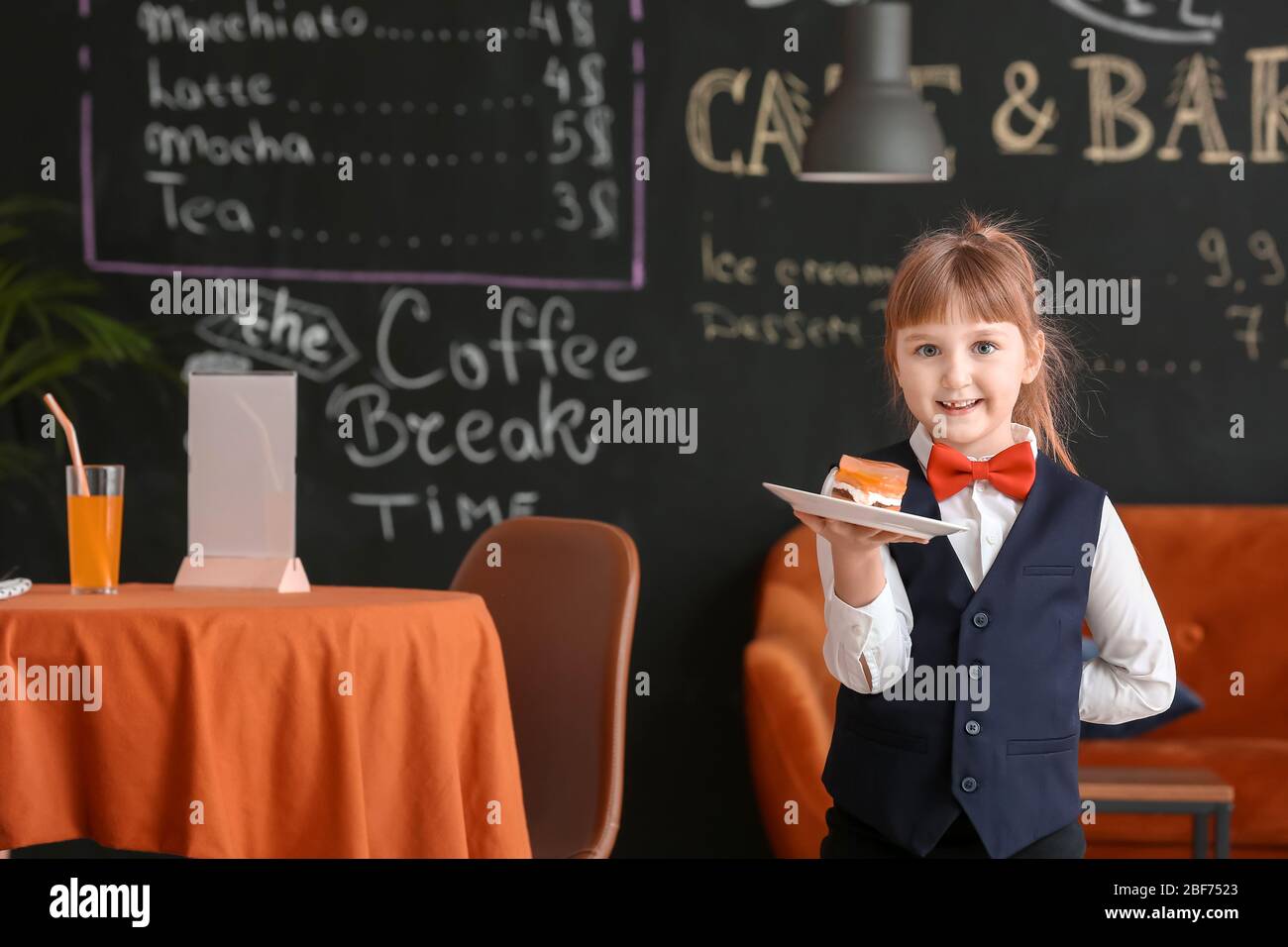 Cute little waiter in restaurant Stock Photo - Alamy