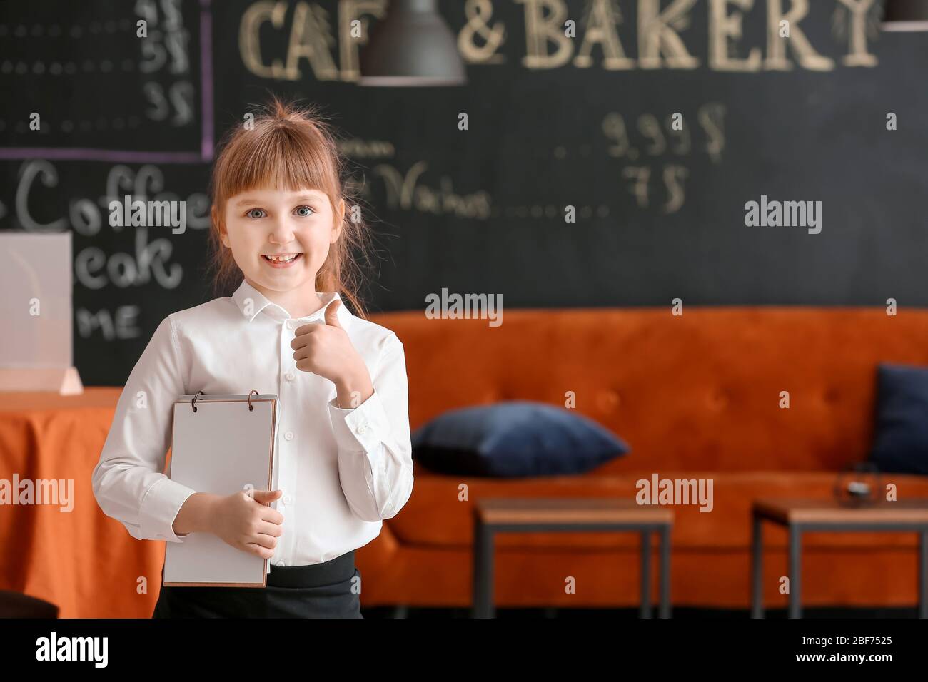 Cute little waiter in restaurant Stock Photo - Alamy