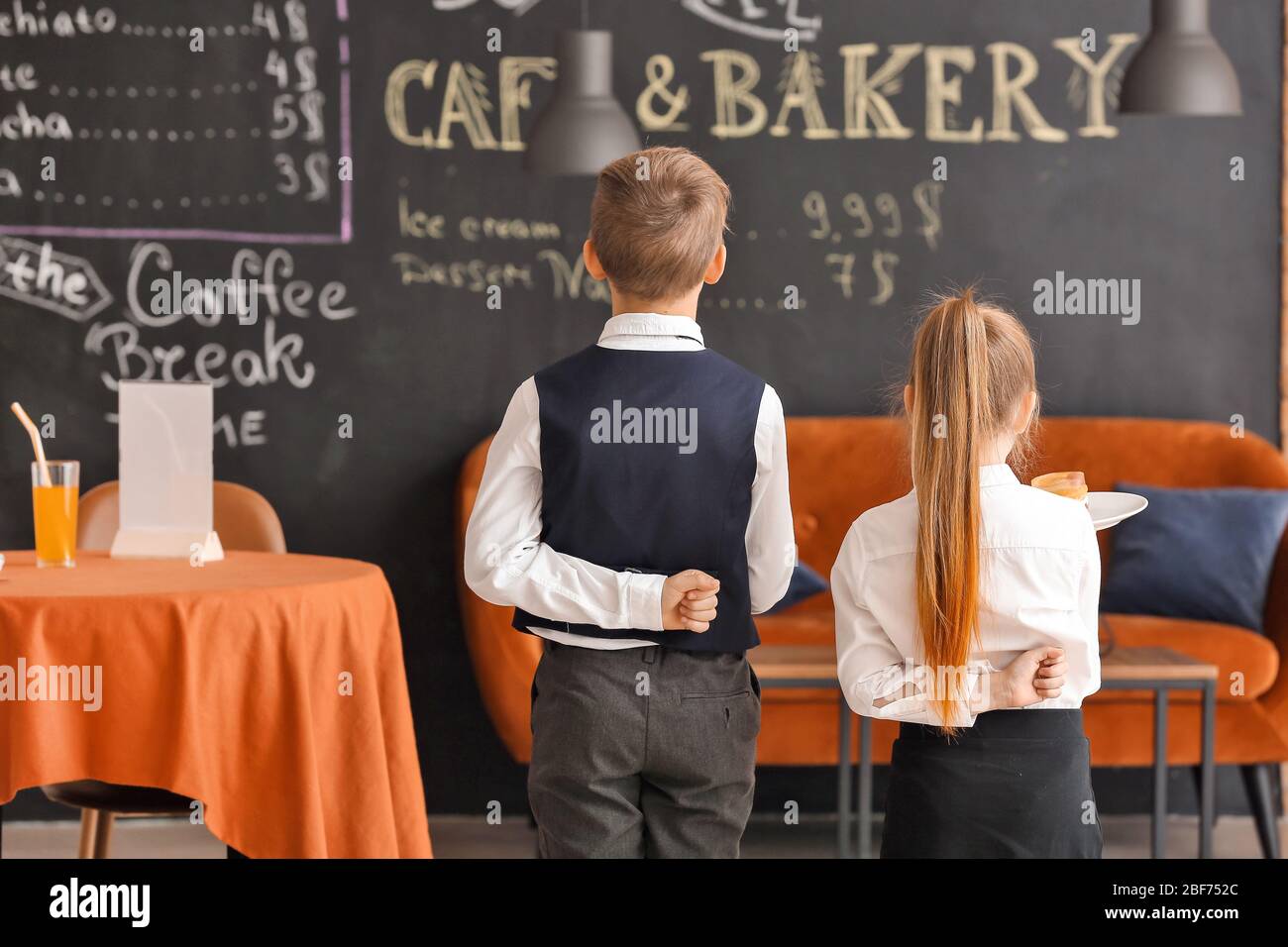 Cute little waiters in restaurant Stock Photo - Alamy
