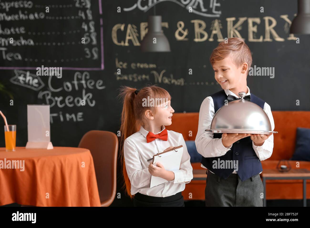 Cute little waiters in restaurant Stock Photo - Alamy