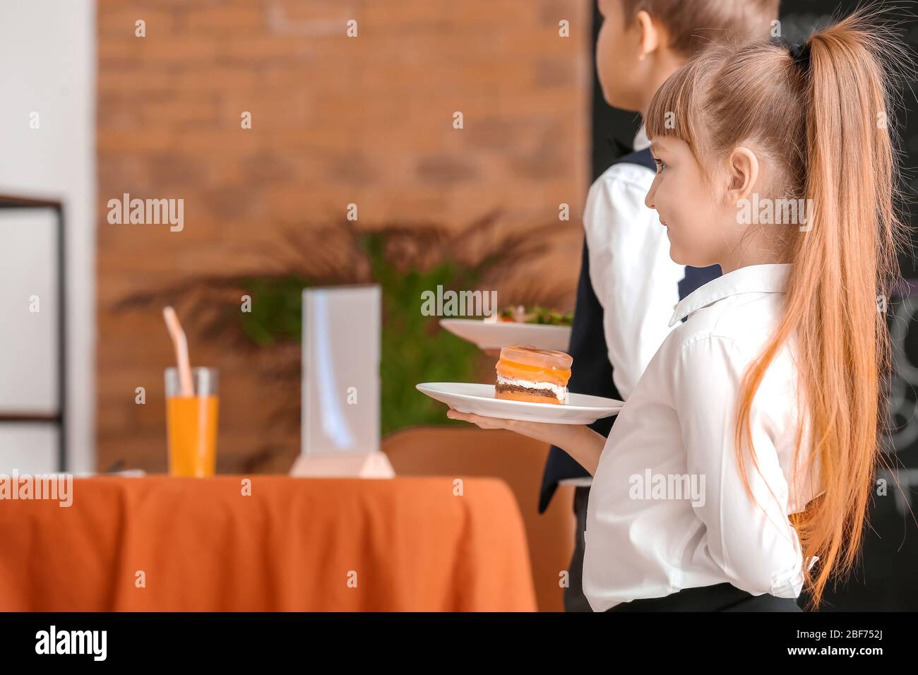 Cute little waiters in restaurant Stock Photo - Alamy