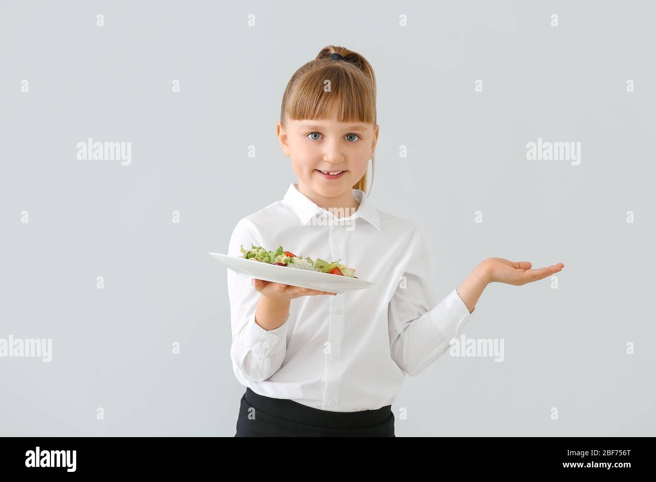 Cute little waiter on light background Stock Photo - Alamy