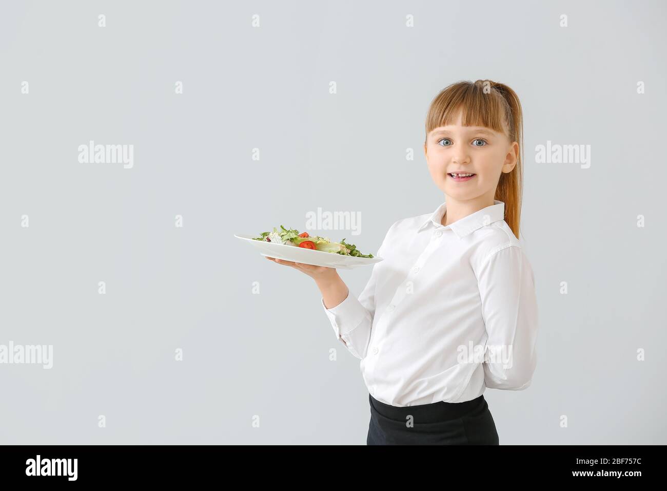 Cute little waiter on light background Stock Photo - Alamy