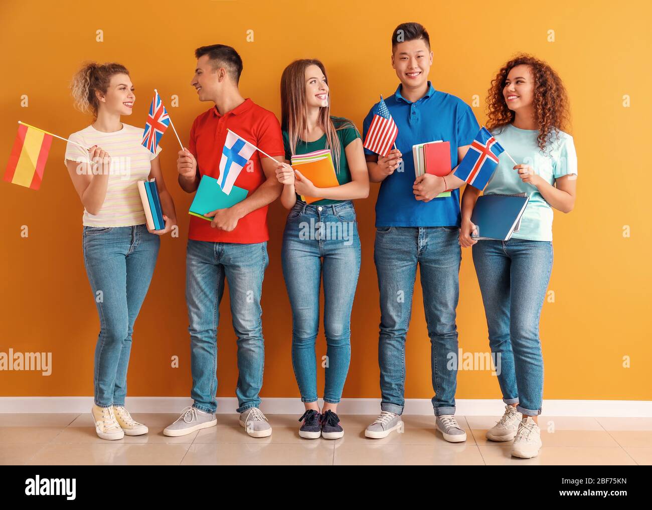 Young students of language school near color wall Stock Photo - Alamy