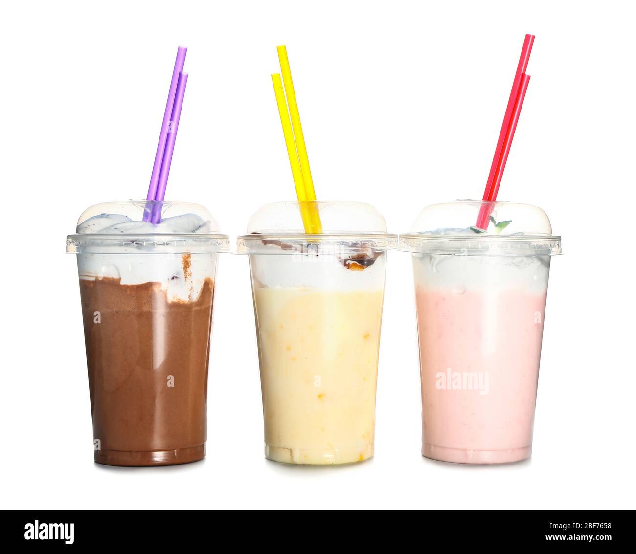 Cups of tasty milkshakes on white background Stock Photo - Alamy