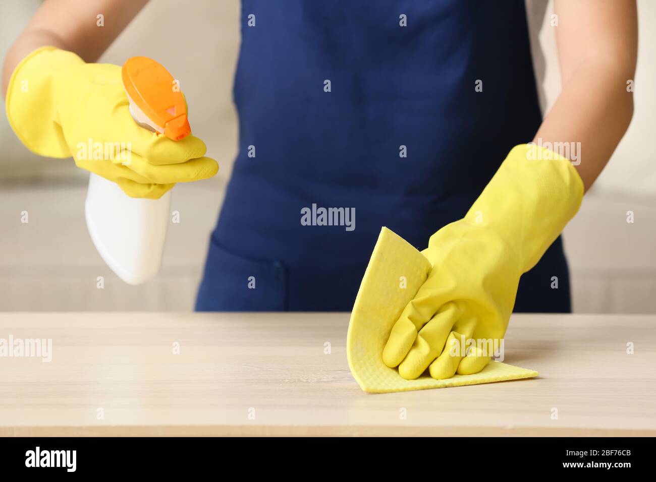 Janitor cleaning table in apartment Stock Photo - Alamy