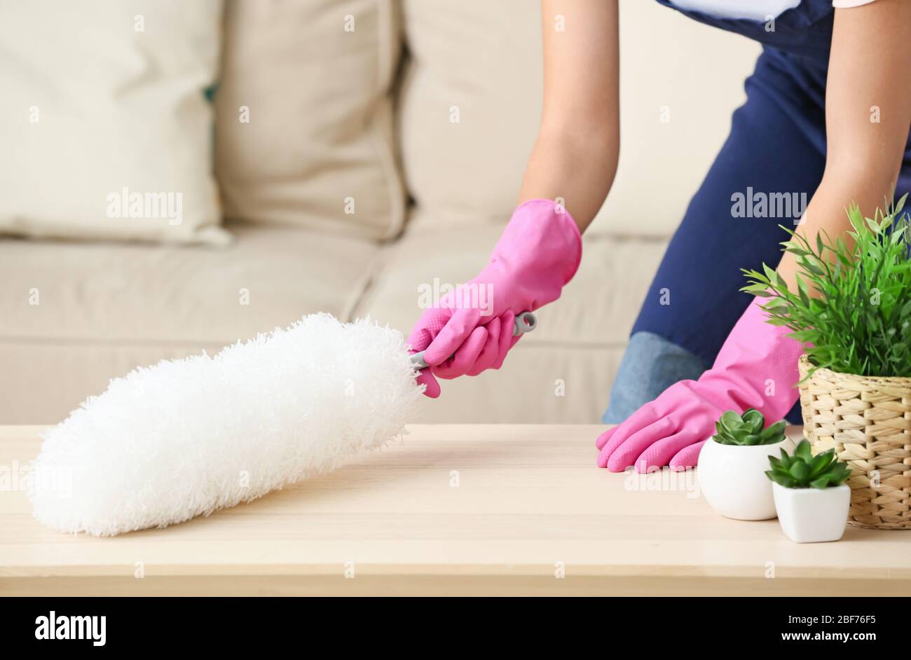 Janitor cleaning table in apartment Stock Photo - Alamy