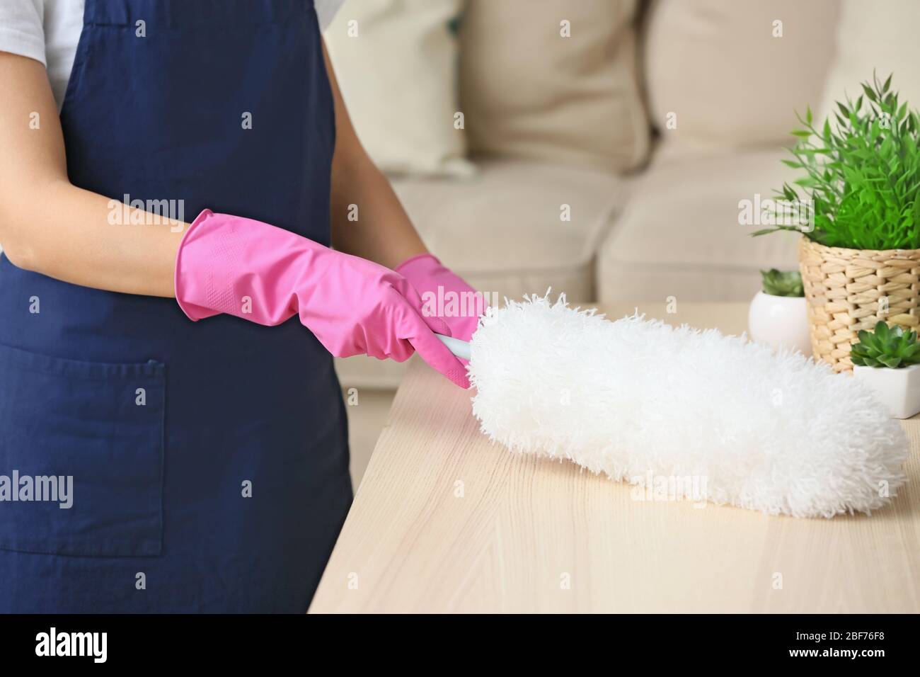 Janitor cleaning table in apartment Stock Photo - Alamy
