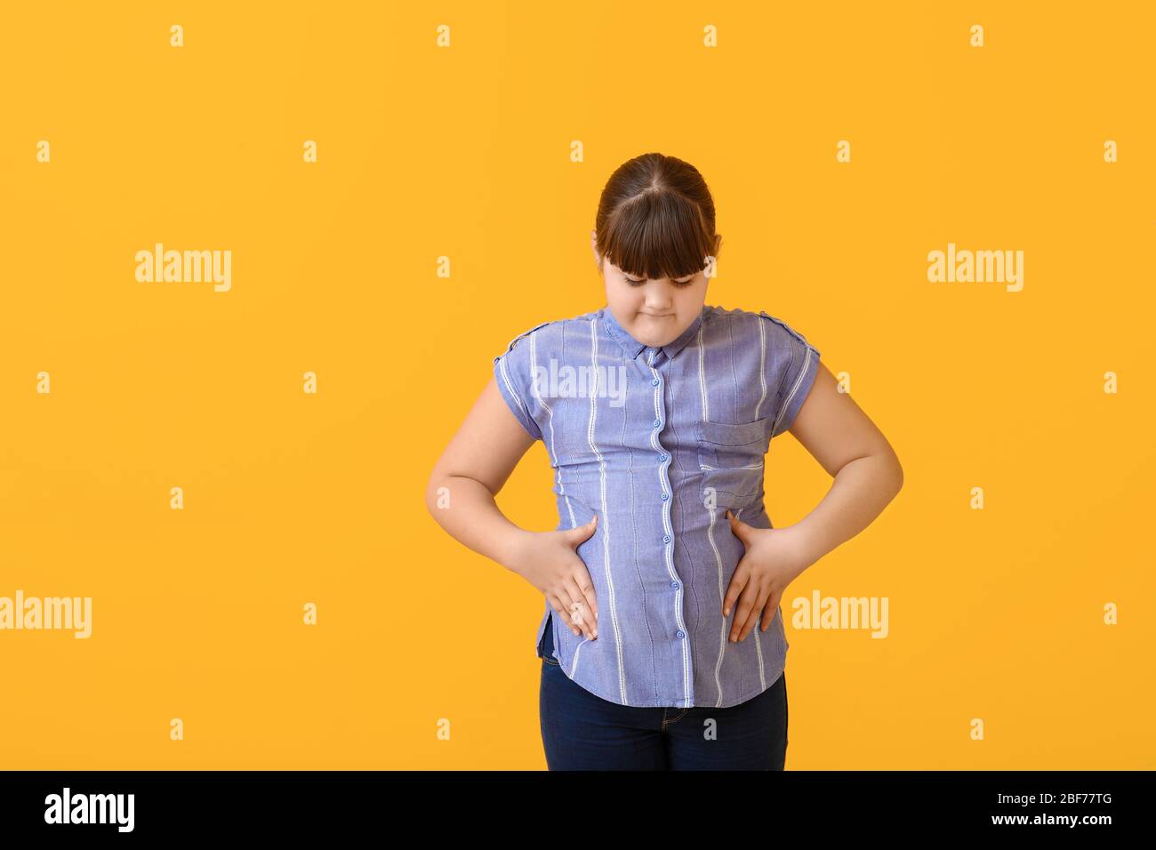 Sad overweight girl on color background Stock Photo - Alamy
