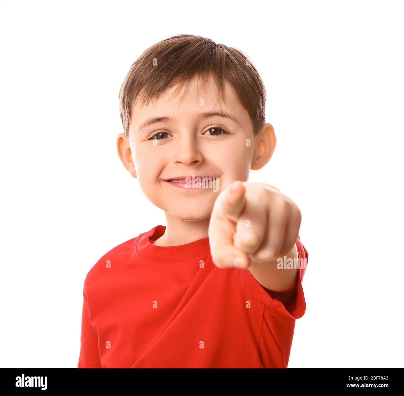 Happy smiling little boy pointing at viewer against white background ...