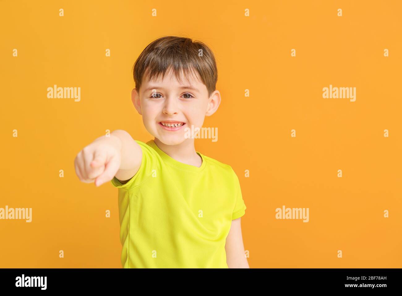 Happy smiling little boy pointing at viewer on color background Stock ...