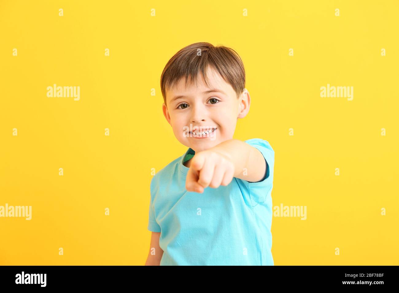 Happy smiling little boy pointing at viewer on color background Stock ...