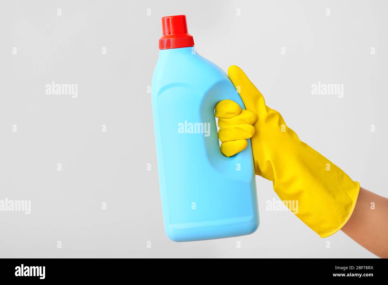 Hand of janitor with detergent on light background Stock Photo - Alamy