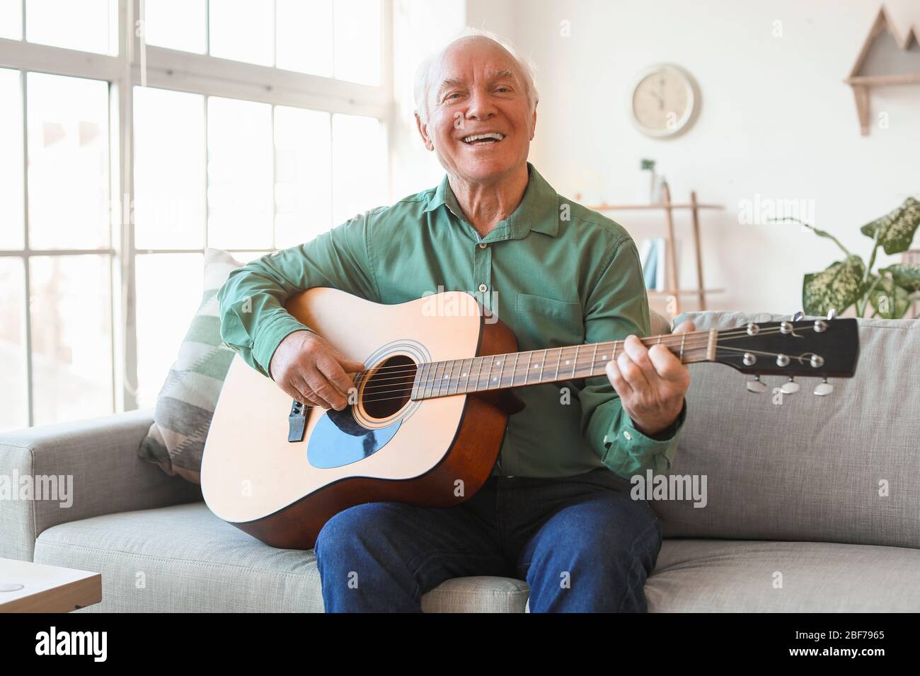 Elderly man playing guitar at home Stock Photo - Alamy