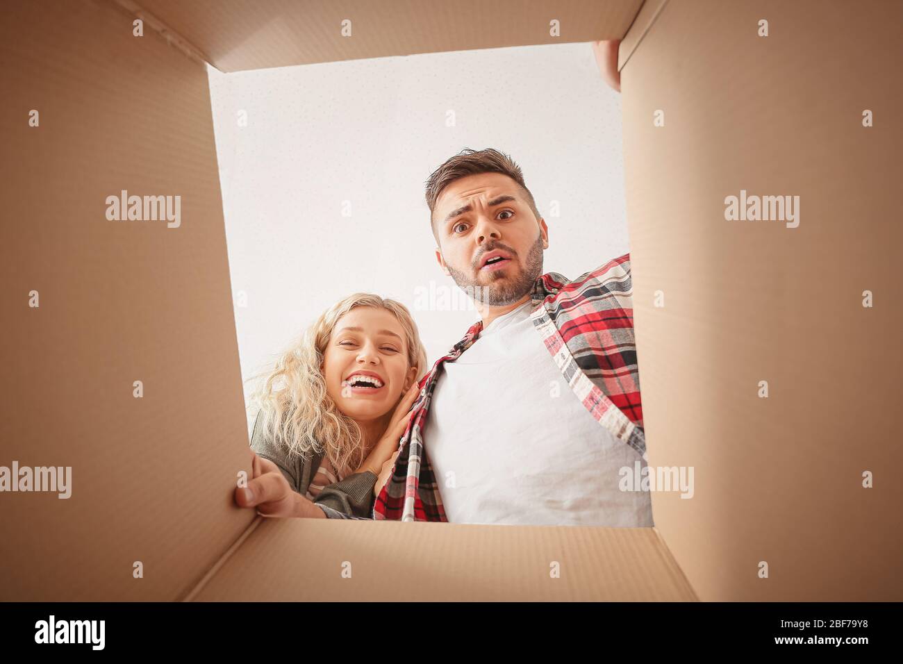 Emotional young couple with open moving box, view from inside Stock ...