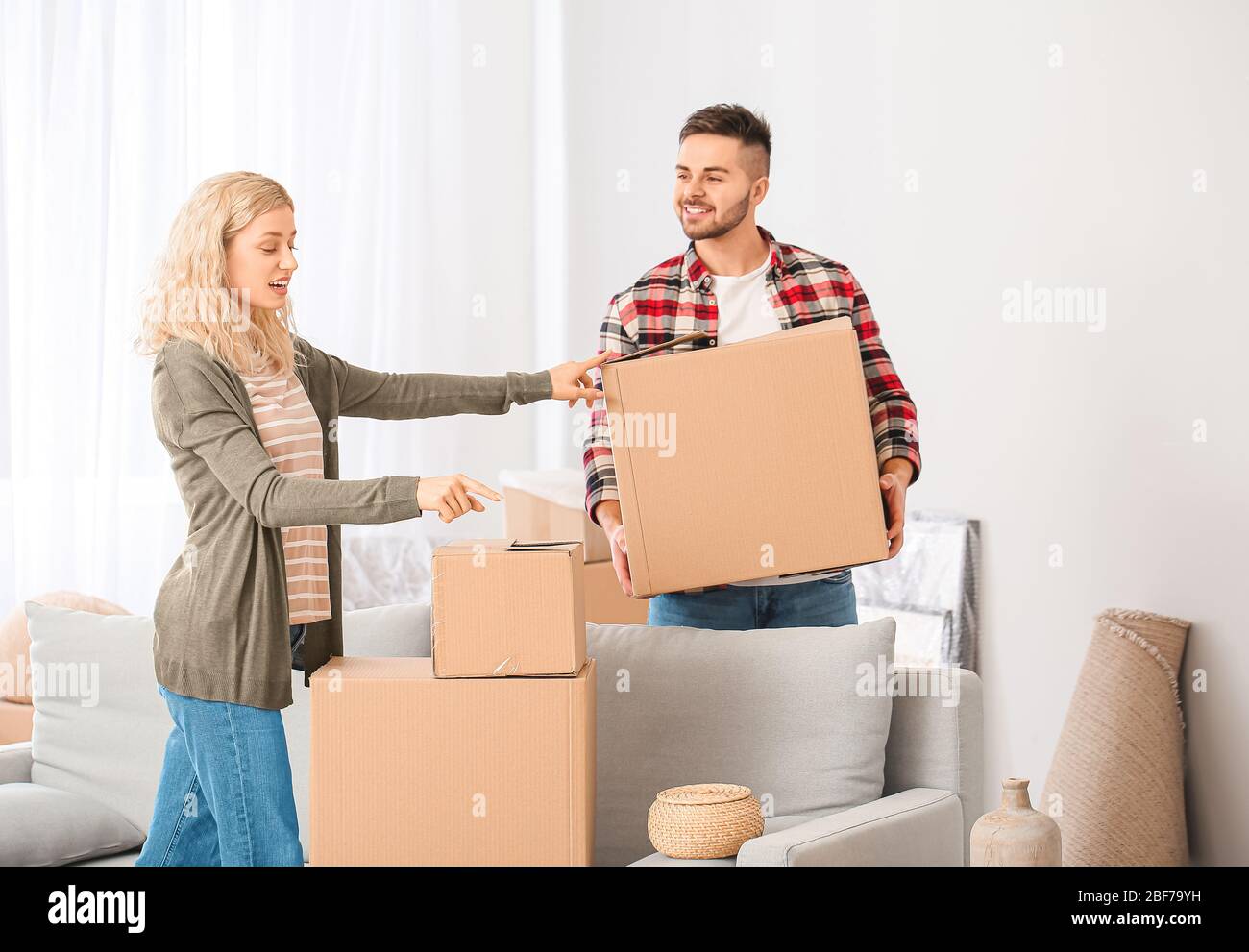 Couple with moving boxes in their new home Stock Photo - Alamy