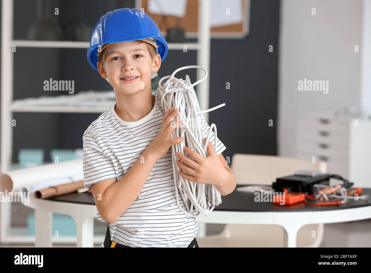Cute little electrician in room Stock Photo - Alamy