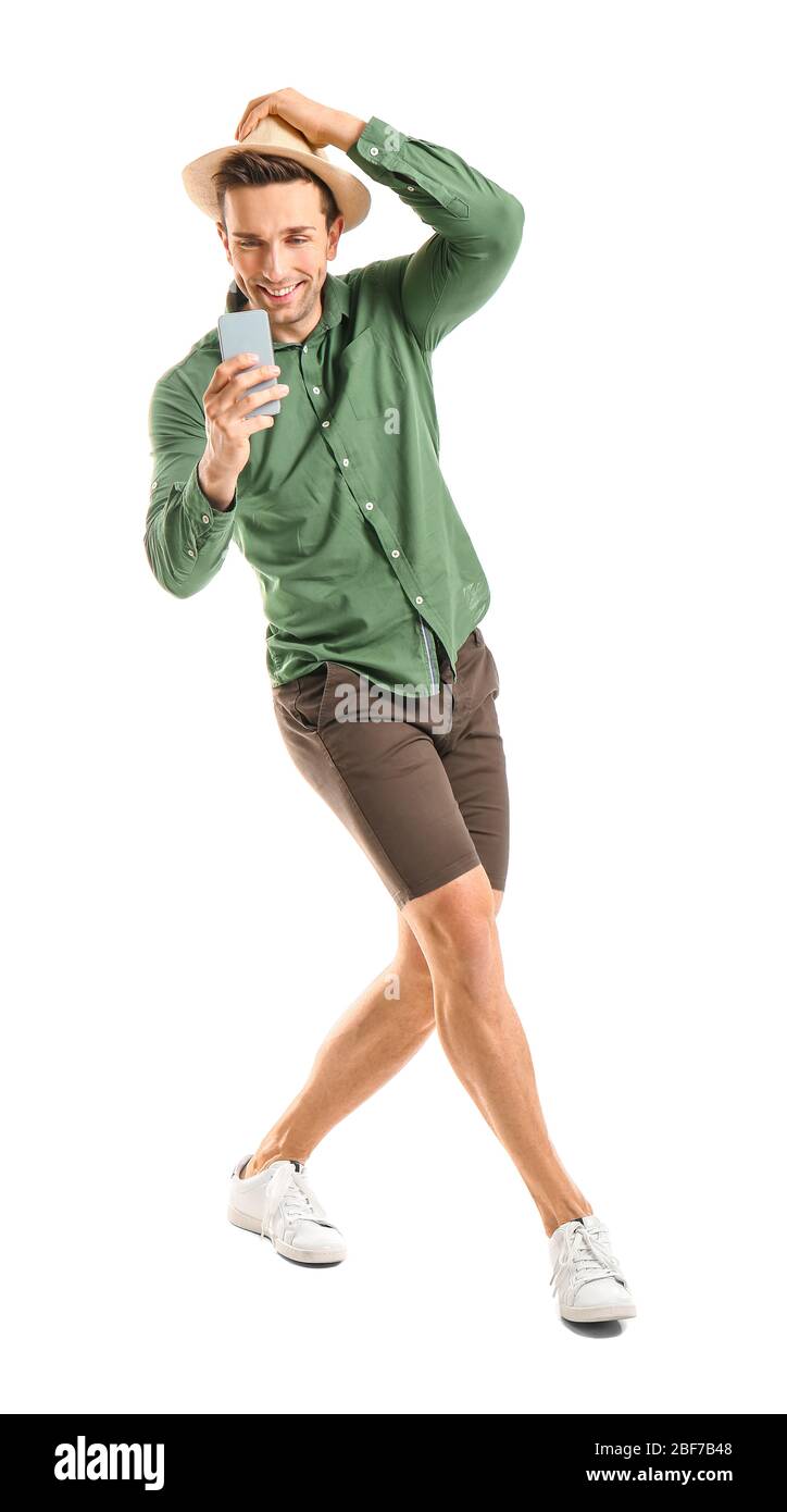 Cool young man with mobile phone dancing against white background Stock ...