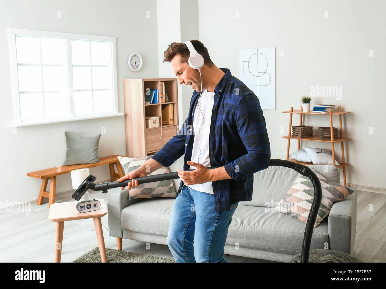 Cool young man dancing and singing while cleaning his flat Stock Photo ...