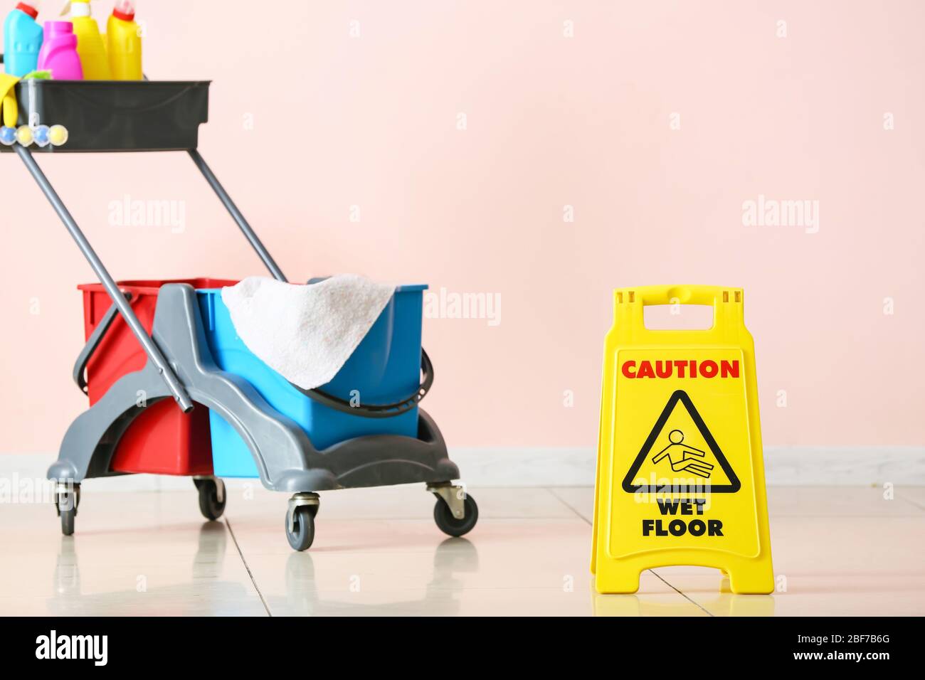 Caution sign with janitor's trolley indoors Stock Photo - Alamy