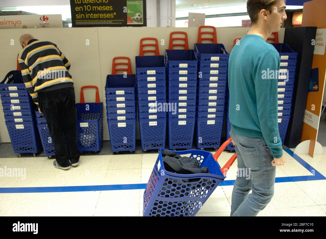 a customer entering a supermarket with a shopping basket Stock Photo ...