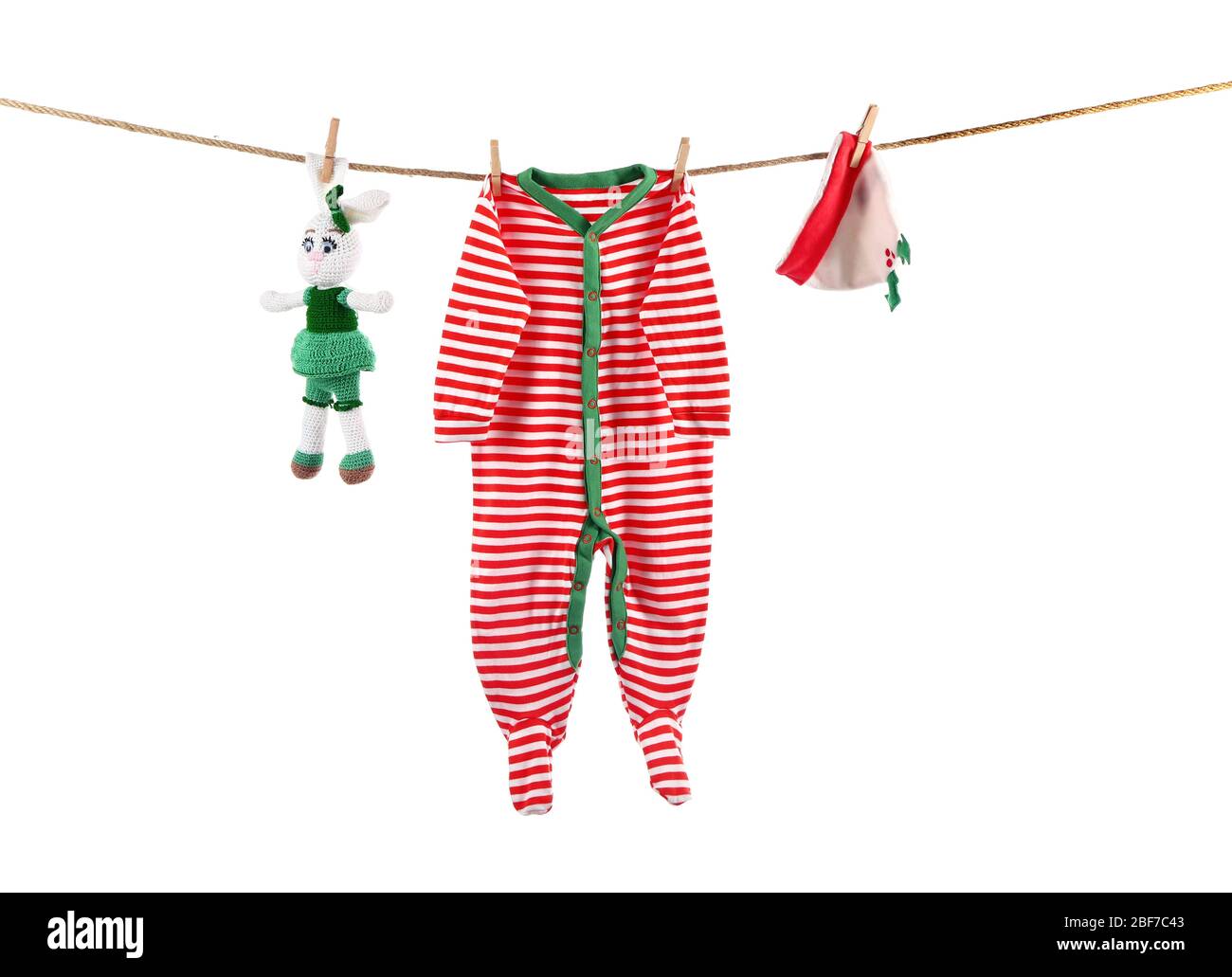 Baby clothes and accessories hanging on rope against white background ...