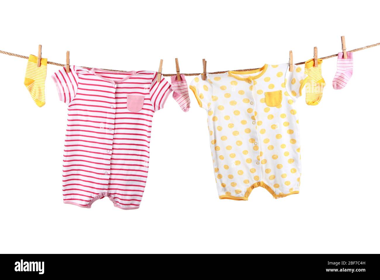 Baby clothes hanging on rope against white background Stock Photo - Alamy