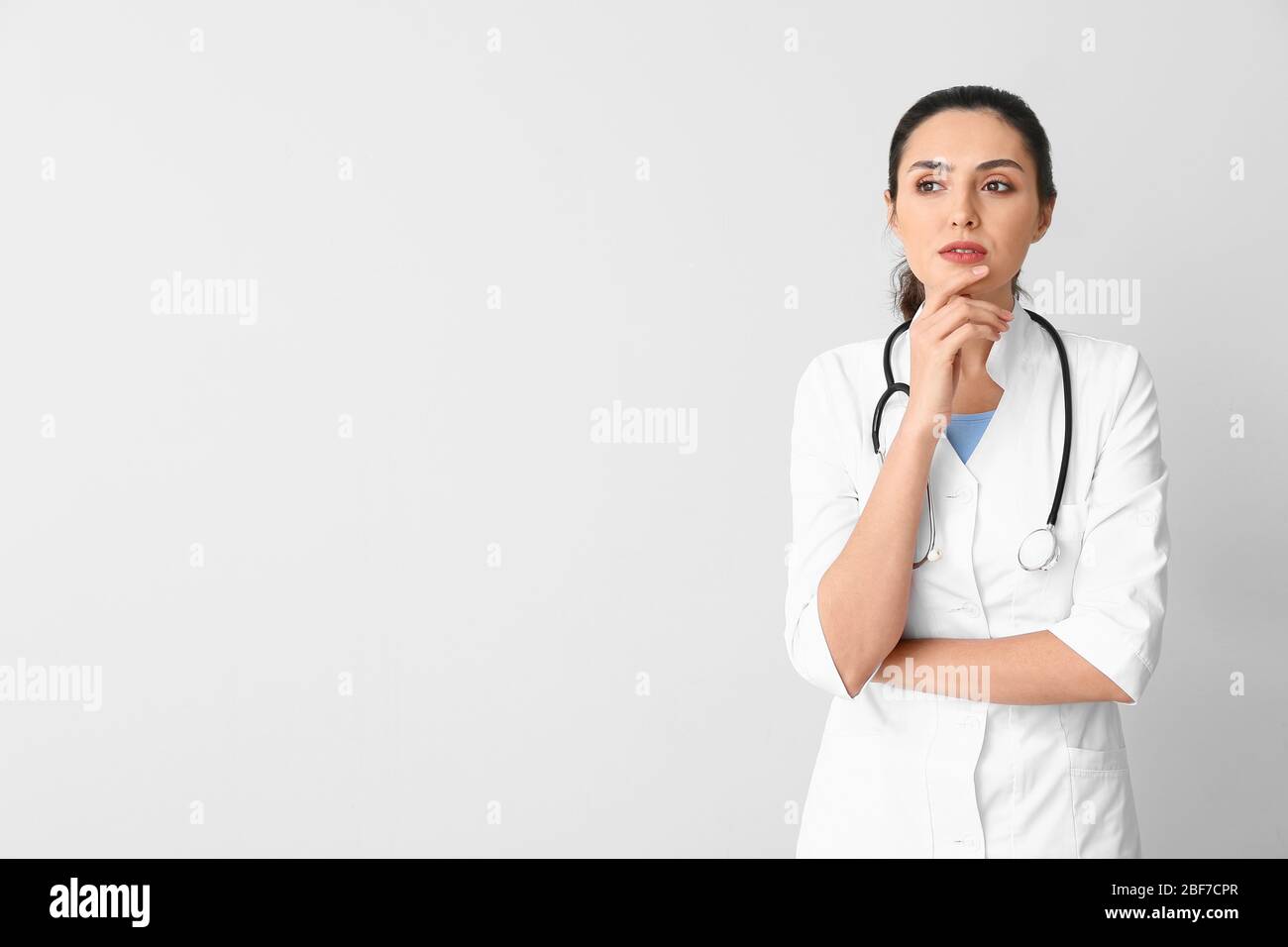Portrait of young female doctor on light background Stock Photo - Alamy