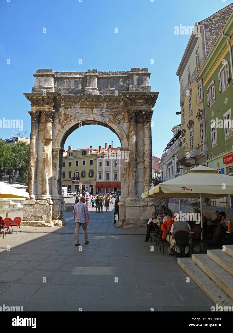 Pedestrians passing through the "Golden Gate" of Pula. Known as the ...