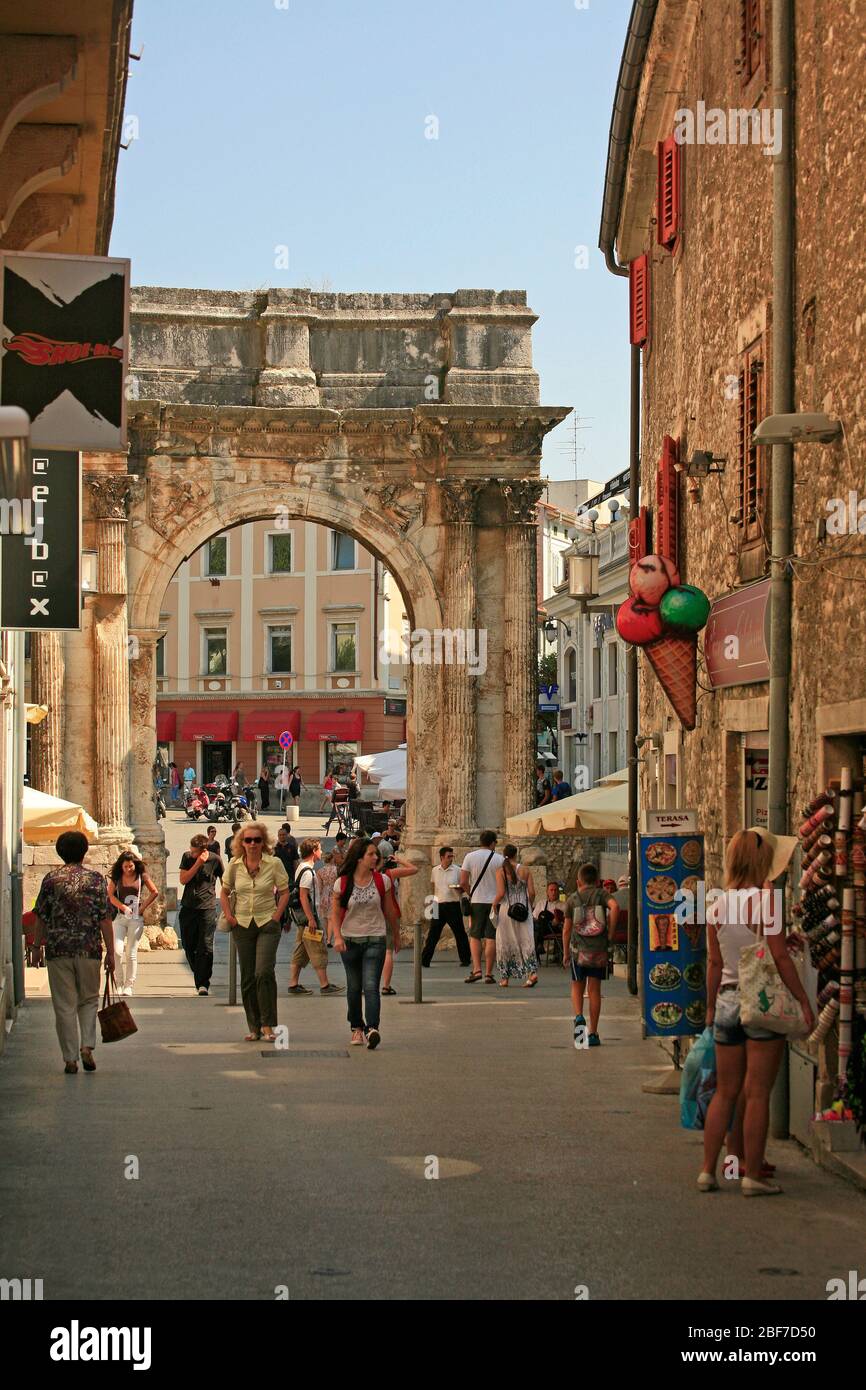 Pedestrians passing through the "Golden Gate" of Pula. Known as the ...