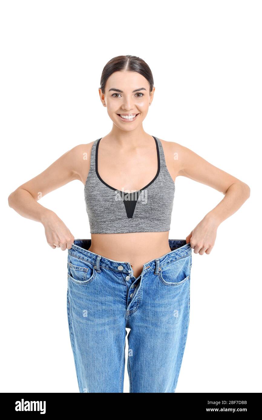 Young woman in loose clothes on white background. Weight loss concept ...