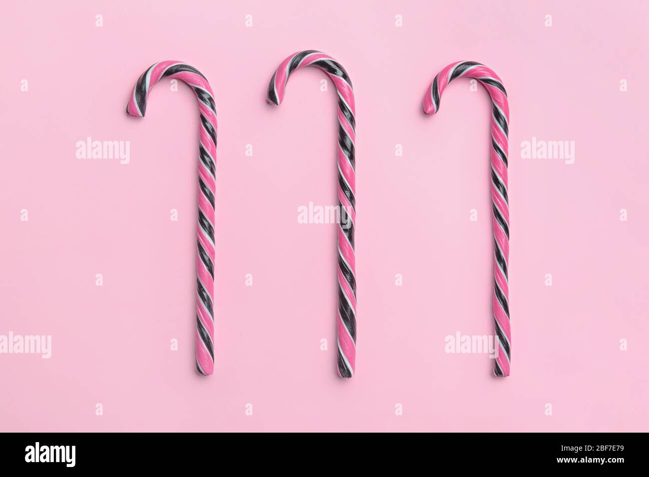 Tasty candy canes on color background Stock Photo - Alamy