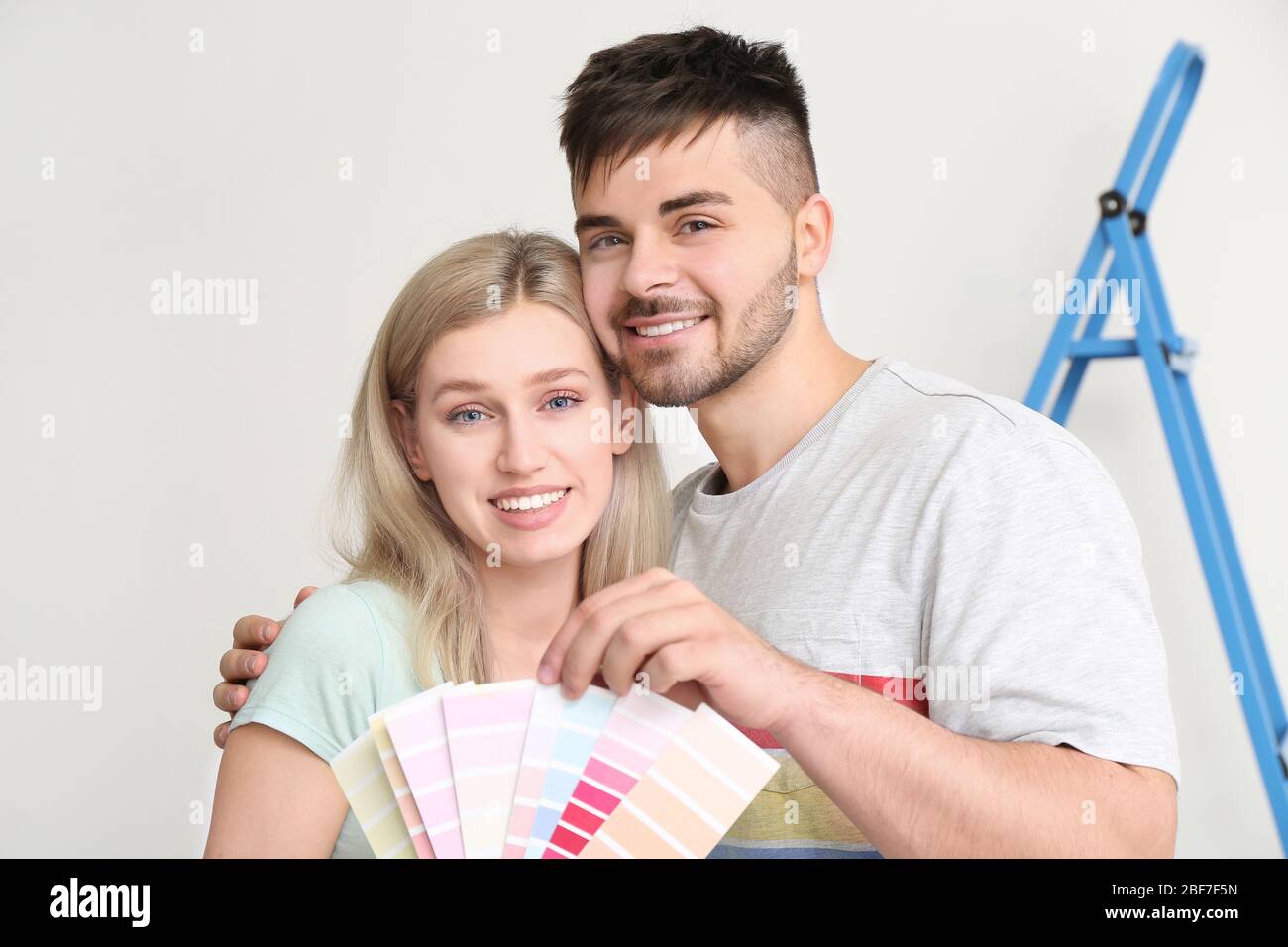 Young couple with color swatches on white background Stock Photo - Alamy