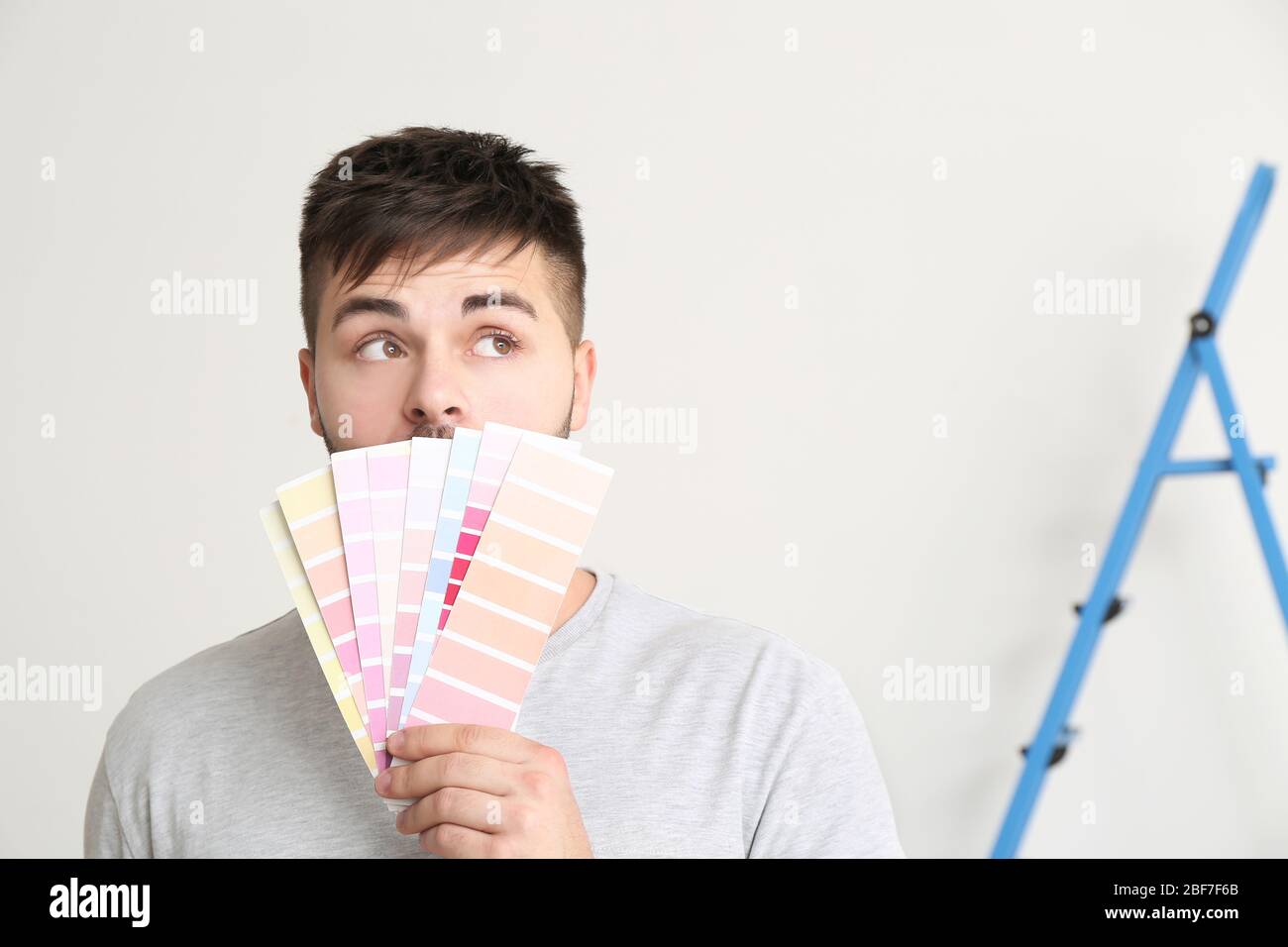 Young man with color swatches on white background Stock Photo - Alamy