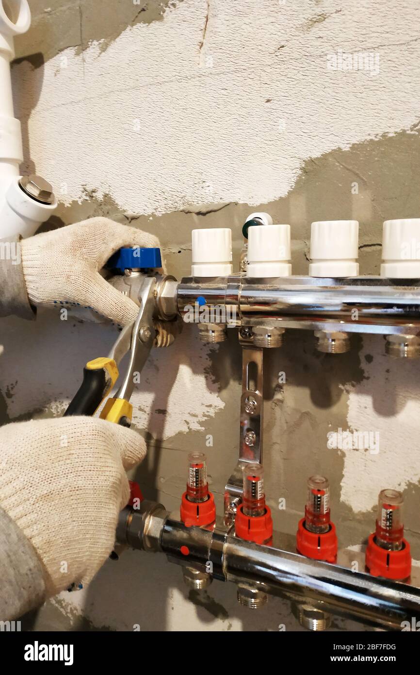 Installation of heating a new home, the worker connects the pipe to the ...