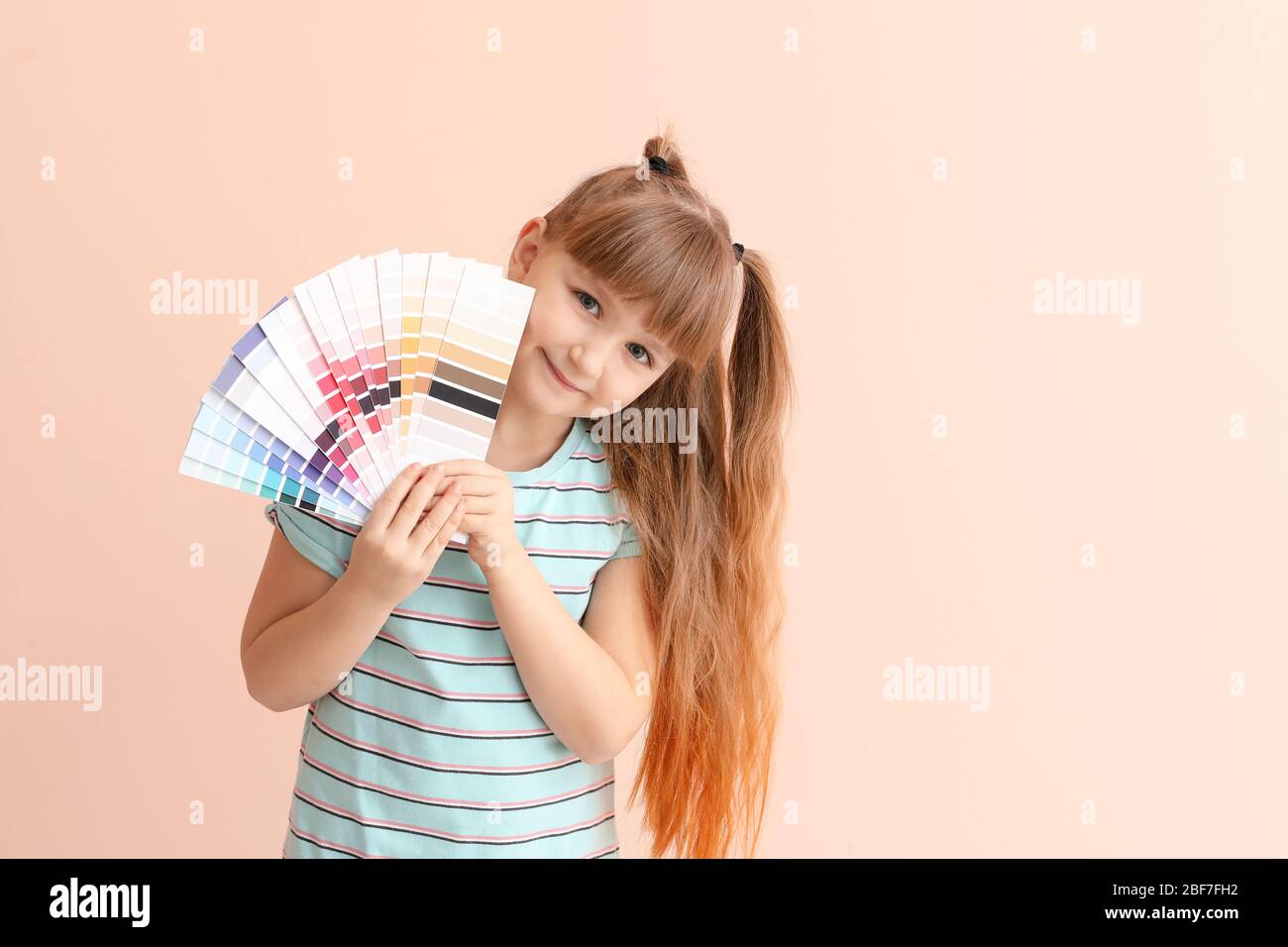 Little girl with color palettes on pink background Stock Photo - Alamy