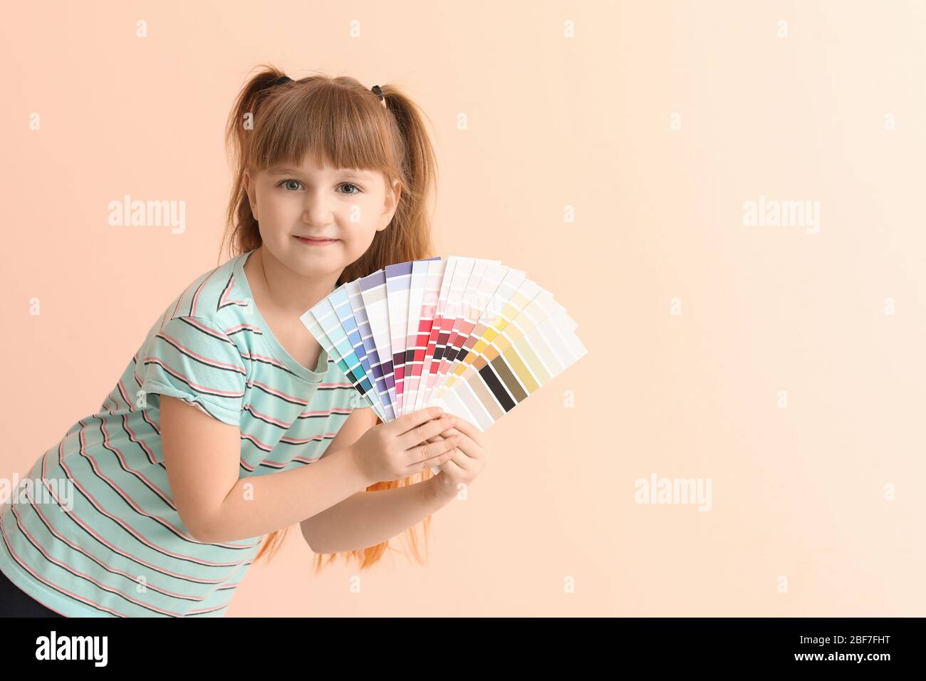Little girl with color palettes on pink background Stock Photo - Alamy