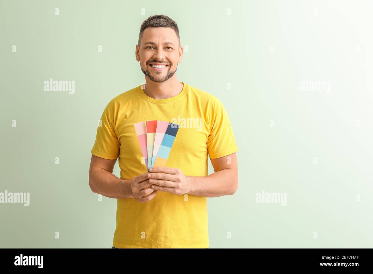 Man with color palettes on green background Stock Photo - Alamy