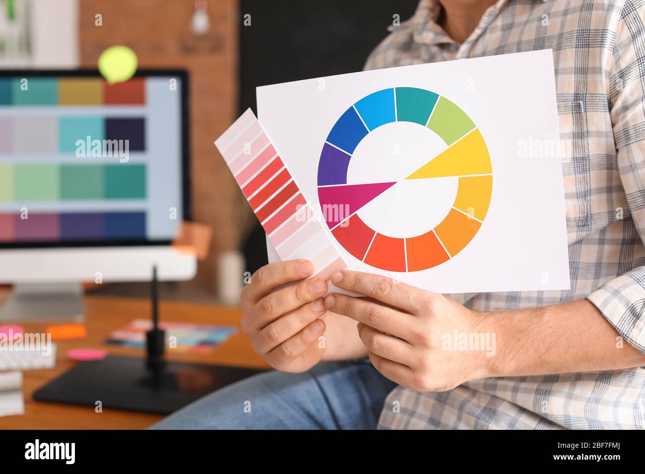 Male designer with color palettes in office Stock Photo - Alamy
