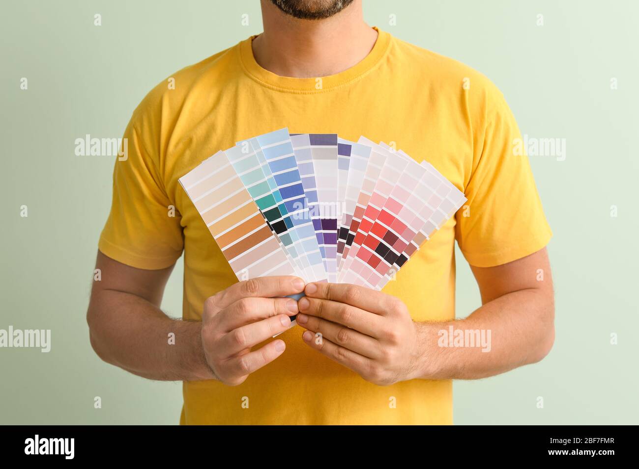 Man with color palettes on green background Stock Photo - Alamy